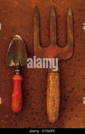 Well-used garden trowel and hand fork lying on rusty metal sheet Stock ...
