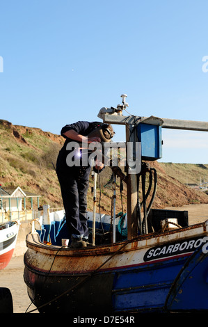 Filey Sands Yorkshire UK. Fishing Coble and fishermen on the Sands ...