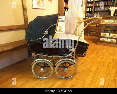 The image depicts an old-fashioned stroller or pram, a vintage design ...