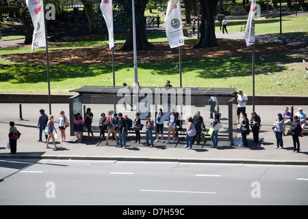 A queue of passengers waiting at a busy bus stop Stock Photo - Alamy