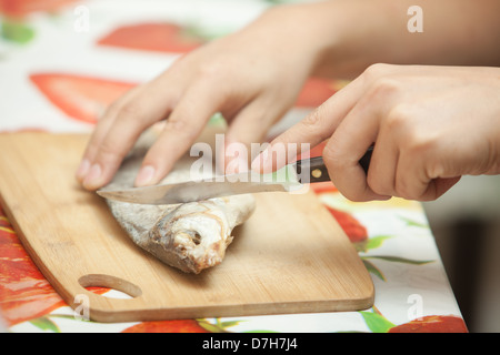 Man's hands with a knife cut the fish on the kitchen blackboard Stock ...