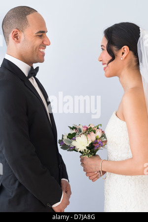A vertical shot of a bride and a groom standing against an old church ...