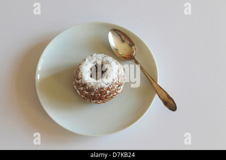 Miniature cakes with powdered sugar and spoon on plate Stock Photo - Alamy