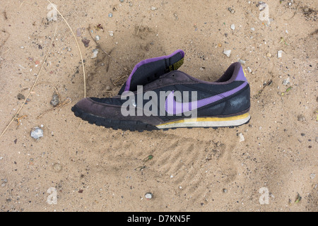 Trainer shoe washed up on the beach along with other rubbish Stock ...