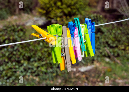 Plastic pegs on a washing line with clothes hanging from the line ...