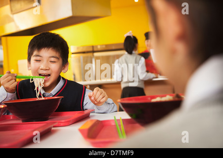 School boy eats noodles in school cafeteria Stock Photo - Alamy