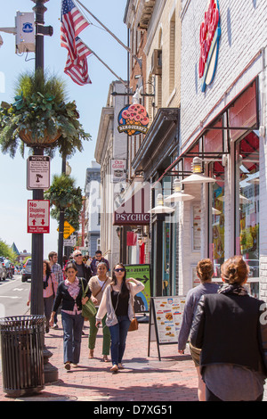 People walking on a crowded sidewalk holding umbrellas in the rain ...
