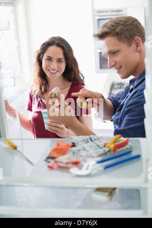 Cheerful repairman standing in the customer kitchen with a new light ...