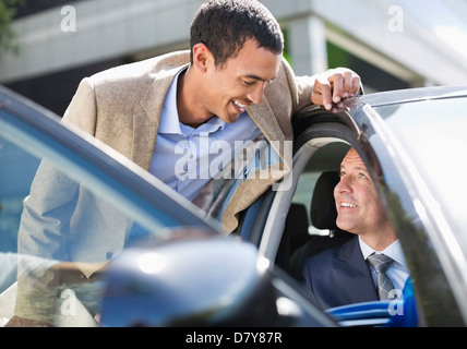 Businessmen talking at car Stock Photo - Alamy