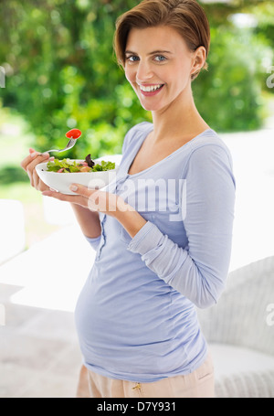 Cheerful expecting lady enjoying healthy snack, bedroom interior Stock ...