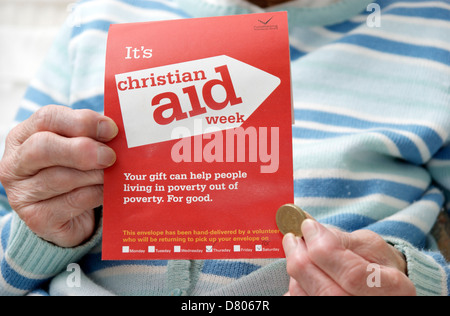 £1 coin donation with charity collecting envelope for Christian Aid ...