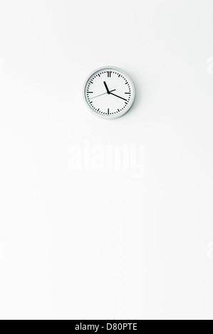 Modern wall clock on a white wall in a bright minimalist interior ...