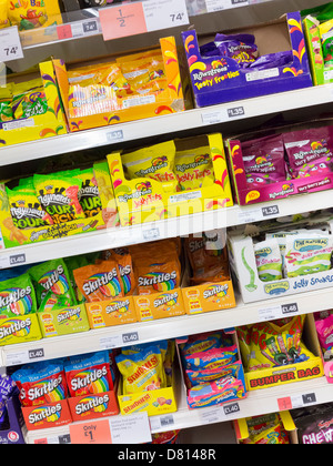 UK supermarket shelves stacked with sweets - a shopper reaches for a ...