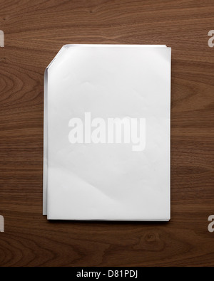 plain sheet of A4 paper with a stapled corner lying flat on a wooden ...