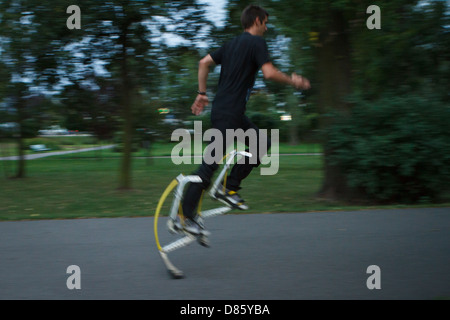 Young man running using jumping stilts Stock Photo - Alamy