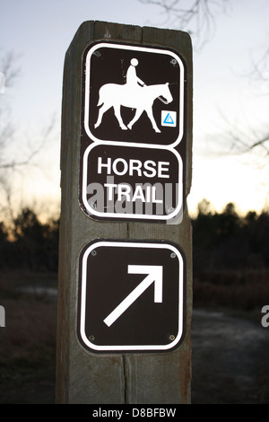 Sign indicating horse riding trail with horseshoe and arrow in wood ...