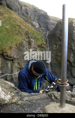 Elie Chain Walk - man using the chain to help traverse a ledge of the ...
