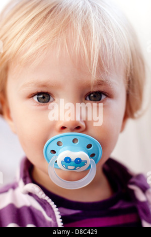 Portrait of a blonde toddler with a pacifier Stock Photo - Alamy