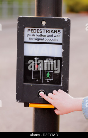 Hand pressing a button at traffic lights on pedestrian crossing ...