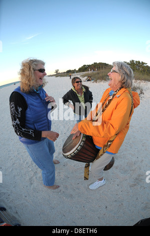 A group gathers on Nokomis, Florida beach to play drums as the sun sets ...