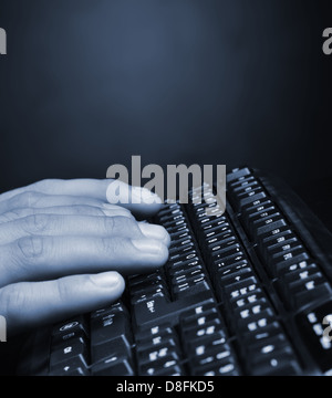 Hands above the keyboard. On a dark background, the black keyboard ...