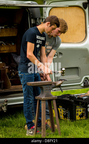 Farrier with a mobile blacksmith van shoeing a horse in an agricultural ...
