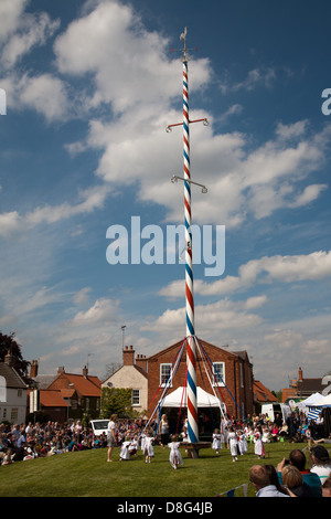 Children dance round the ancient maypole on the village green of Wellow ...