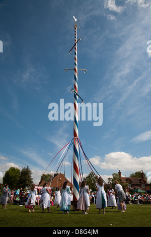 Children dance round the ancient maypole on the village green of Wellow ...