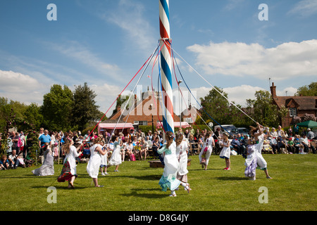 Children dance round the ancient maypole on the village green of Wellow ...
