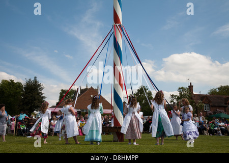 Children dance round the ancient maypole on the village green of Wellow ...