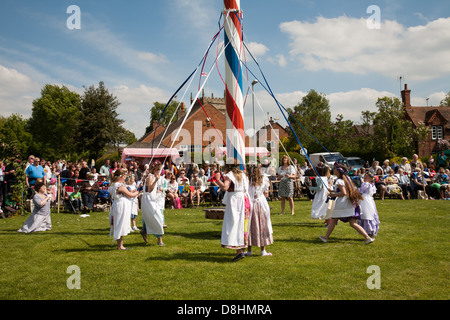 Children dance round the ancient maypole on the village green of Wellow ...