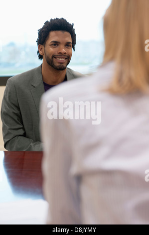 A woman officer interviews a man in an interrogation room with ...
