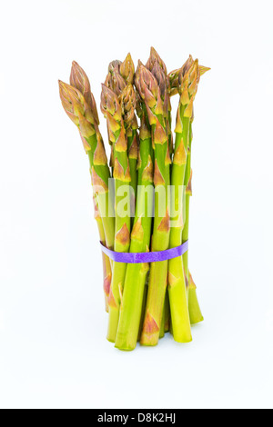 Bunch of fresh green and purple asparagus spears on dark textured wood ...