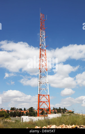 Tall red and white telecommunications mobile and 5G cell tower on hill ...