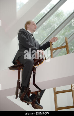 A rider sits on a balk at the ceiling, eats peanuts and throws the ...
