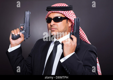 middle eastern bodyguard posing with guns on black background Stock ...