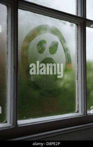 Sad face drawn on the condensation on a rainy window Stock Photo - Alamy