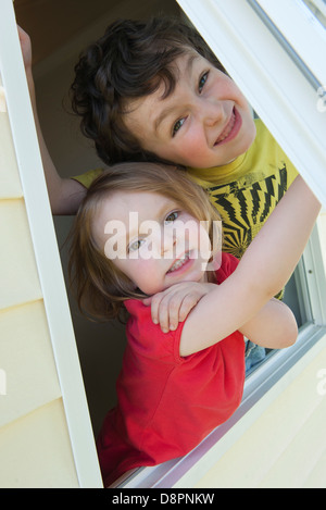 Sisters looking out window with face smashed against glass Stock Photo ...