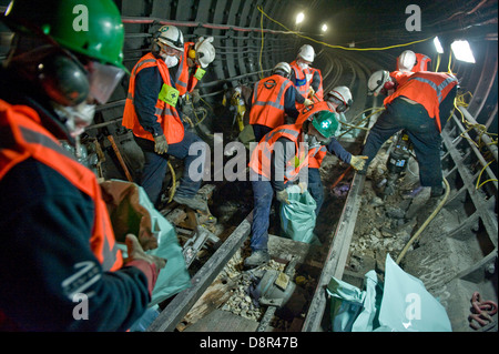 Workers set about digging, bagging up and hauling the old concrete ...