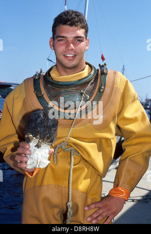A young sponge diver wearing part of a traditional bell diving suit ...