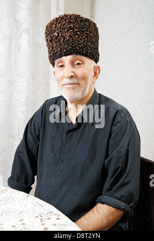 Senior man sitting at table Stock Photo - Alamy