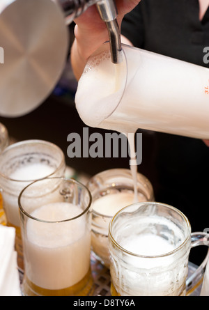 Bartender hands pouring light beer in a beer glass Stock Photo - Alamy