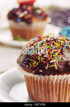 Two fresh homemade muffins with sugar powder and metal strainer closeup ...