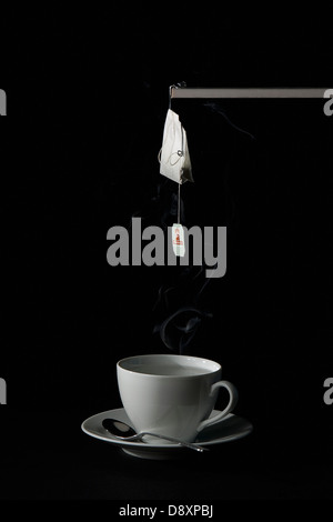 Tea bag diving into a cup Stock Photo - Alamy