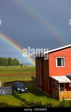 Rainbow over houses Stock Photo - Alamy