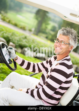 Man driving golf cart Stock Photo - Alamy