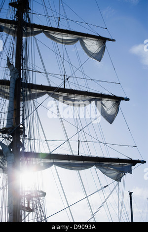 Detail of main mast of tall ship with two seamen on top yard securing ...