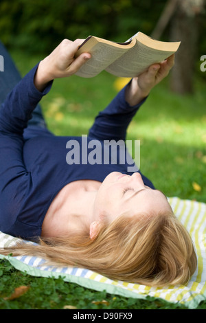 Woman reading in lawn Stock Photo - Alamy