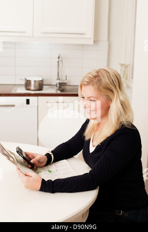 Positive young woman using mobile phone while searching baby white ...
