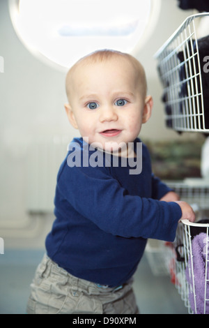 Happy baby trying to stand up while a cheerful father being ready to ...